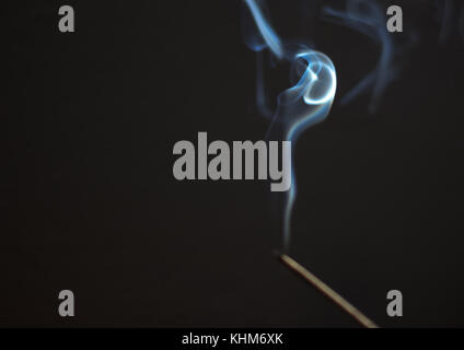 Photograph of an Incense bar and smoke on dark background Stock Photo ...