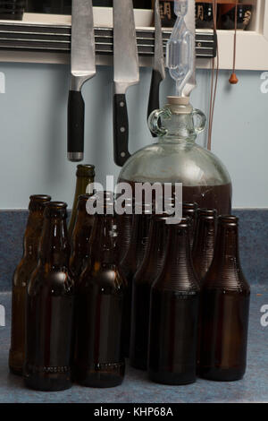 Fermented beer in a demijohn with airlock and hand capper with dark ...
