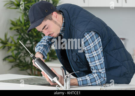 man using caulking gun Stock Photo - Alamy
