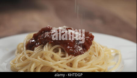 sprinkle grated aged parmesan cheese over spaghetti bolognese Stock ...
