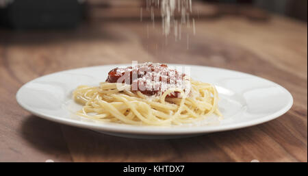 sprinkle grated aged parmesan cheese over spaghetti bolognese Stock ...