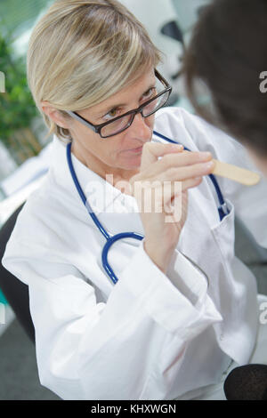 Doctor checking patients tonsils Stock Photo - Alamy