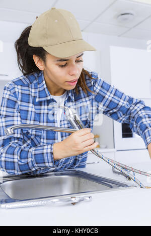 Female plumber fitting kitchen tap Stock Photo - Alamy