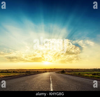 good sunset over asphalt road Stock Photo - Alamy