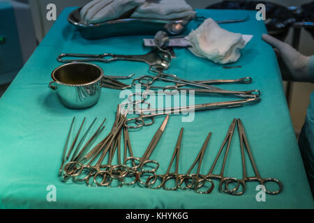 Surgeon and a nurse using forceps to stretch open an incision on a ...