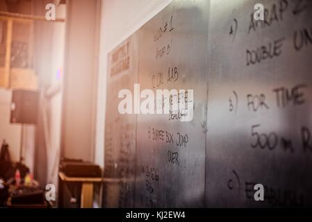 Metal board with written crossfit exercises for the workout of the day ...