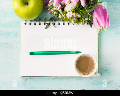 Rose flowers and good morning wish in notepad. Close up. White wooden ...