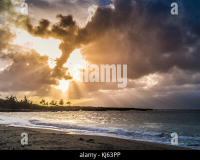 Beams of sunlight pushing through the clouds on the beach at D.T ...