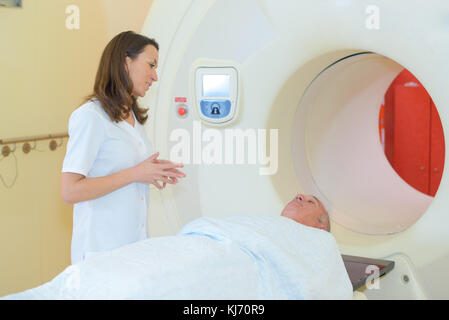 Nurse talking to patient entering scanner Stock Photo - Alamy