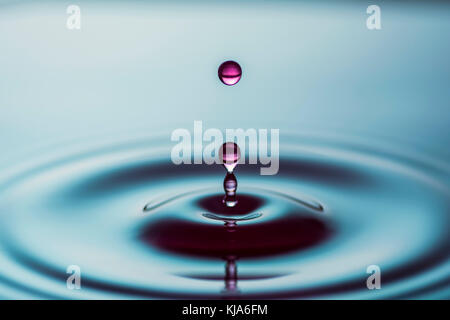 Water drop falling and drips on water mirror. Water drop splash and ...