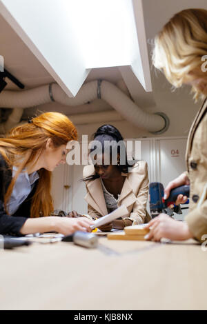 smiling creative team looking at sketch Stock Photo - Alamy