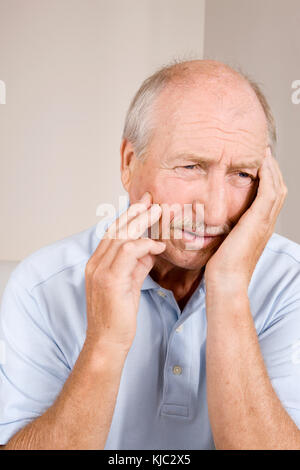 Worried senior man leaning on kitchen sink suffering from mental ...