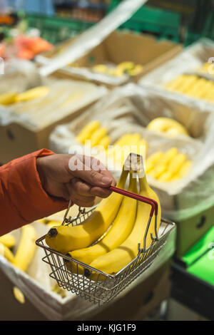 Young woman choosing bananas at grocery store Stock Photo - Alamy