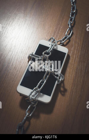 Smart phone and chains. Padlock Stock Photo - Alamy