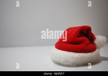 Closeup shot of a Santa hat and red Christmas tree ornaments on a ...
