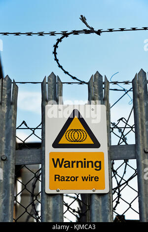 Warning sign on wire fence around building site saying construction ...