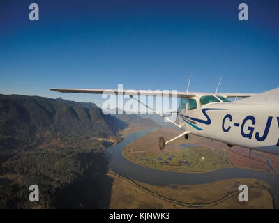 Small airplane flying over the Canadian Mountain Landscape during a ...