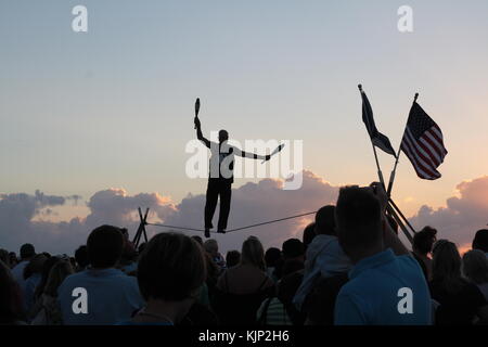 Acrobat walking on a wire at sunset in Mallory Square, Key West ...