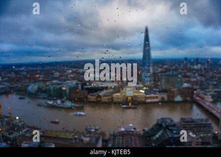 London behind the waterdrops and Thames river at sunset against a ...