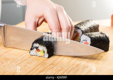 Japanese cuisine. Chef cuts rolls, hands close-up Stock Photo - Alamy