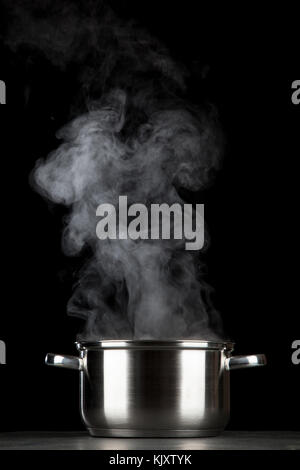 Steaming pot on black background Stock Photo - Alamy