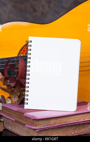 Classical acoustic guitar and an open notebook on a black background ...