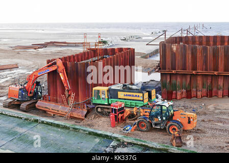 Marine engineers working on cofferdams at low tide during construction ...