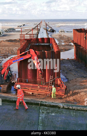 Marine engineers working on cofferdams at low tide during construction ...