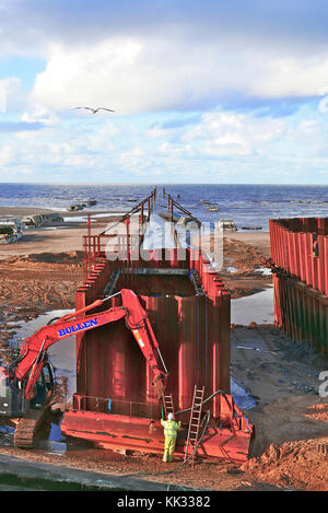 Marine engineers working on cofferdams at low tide during construction ...