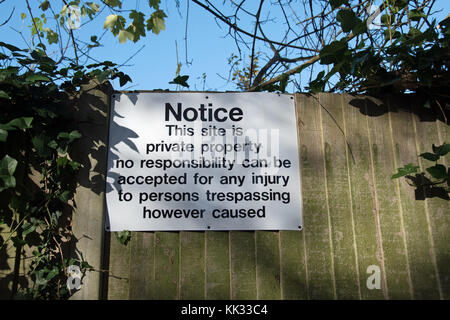 Barrier with sign warning trespassers Stock Photo - Alamy