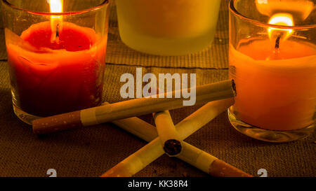 Different configurations with cigarettes and burning candles Stock ...