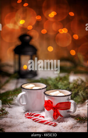 Cup with sweet candy canes and Christmas decor on wooden background ...