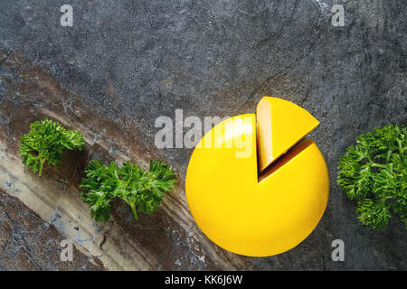 Round gouda cheese with parsley. Dark background Stock Photo - Alamy