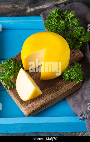 Round gouda cheese with parsley. Dark background Stock Photo - Alamy