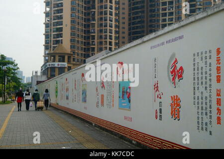 Shenzhen, China: street propaganda walls, painted walls, tourists pass ...