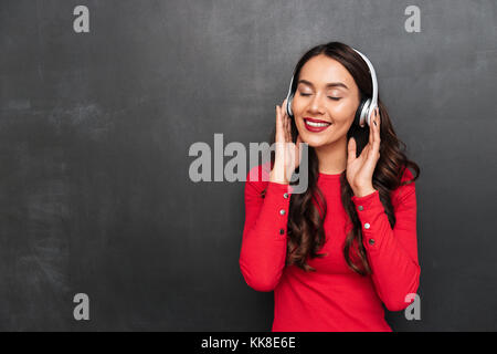 Young brunette woman over grunge grey wall wearing big sunglasses very ...