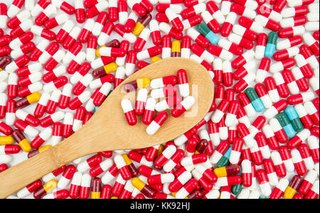 Spoon and capsules on blue backdrop with copy space. Monochrome flat ...