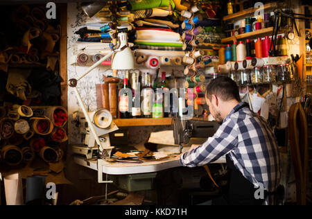 Male worker stitching new belt Stock Photo - Alamy
