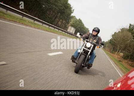 Man with a handlebar moustache riding a Harley Davidson motorcycle with ...