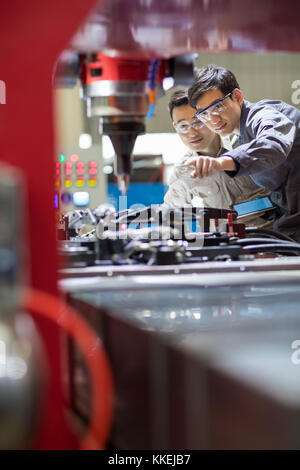 Young Chinese engineers checking machine in the factory Stock Photo - Alamy