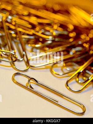 Paper clips together in pile, connected and a chain on purple ...