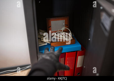 thief stealing valuables from safe at crime scene Stock Photo - Alamy