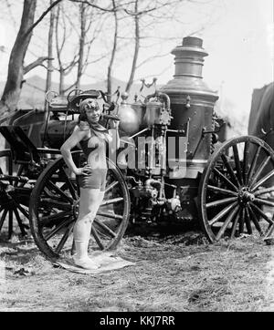 A 1924 photograph of Bea Kyle standing next to a fire engine and a ...