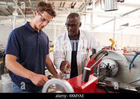 engineer talking to male apprentice at his workstation Stock Photo - Alamy