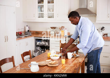 Man Clearing Breakfast Table And Loading Dishwasher Stock Photo - Alamy