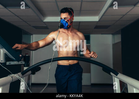 VO2 max test. Fit young man running fast on treadmill with a mask ...