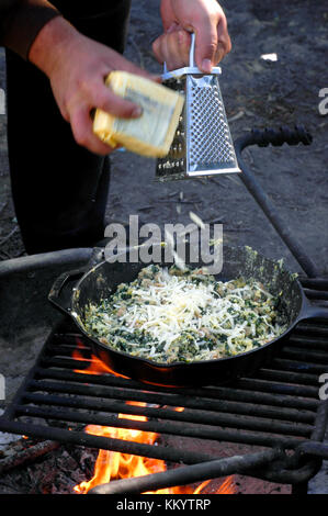 Hand grating cheese with a cheese grater onto a plate Stock Photo - Alamy