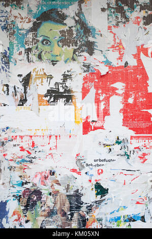 Scraped posters on street wall Stock Photo - Alamy