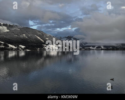 Lake Zell in Austrian Alps, with swan, lamp post and cloud covered lush ...