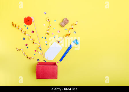 Box with splashed confetti of ribbon, dudes and other festive ...